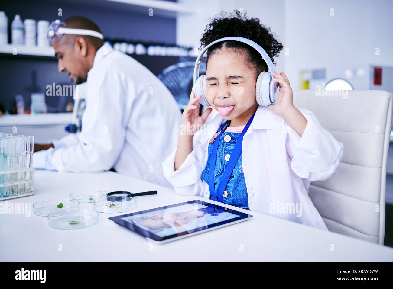 Crazy, lab and child with music and tablet for science with a father or ...