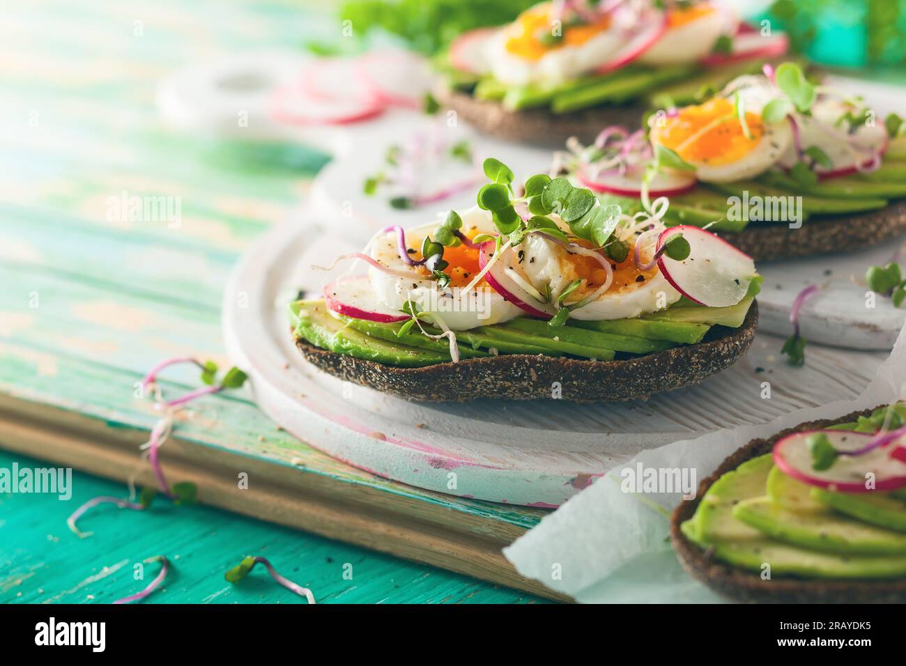 Open sandwiches with avocado,radish, boiled egg and sprouts. Concept of ...