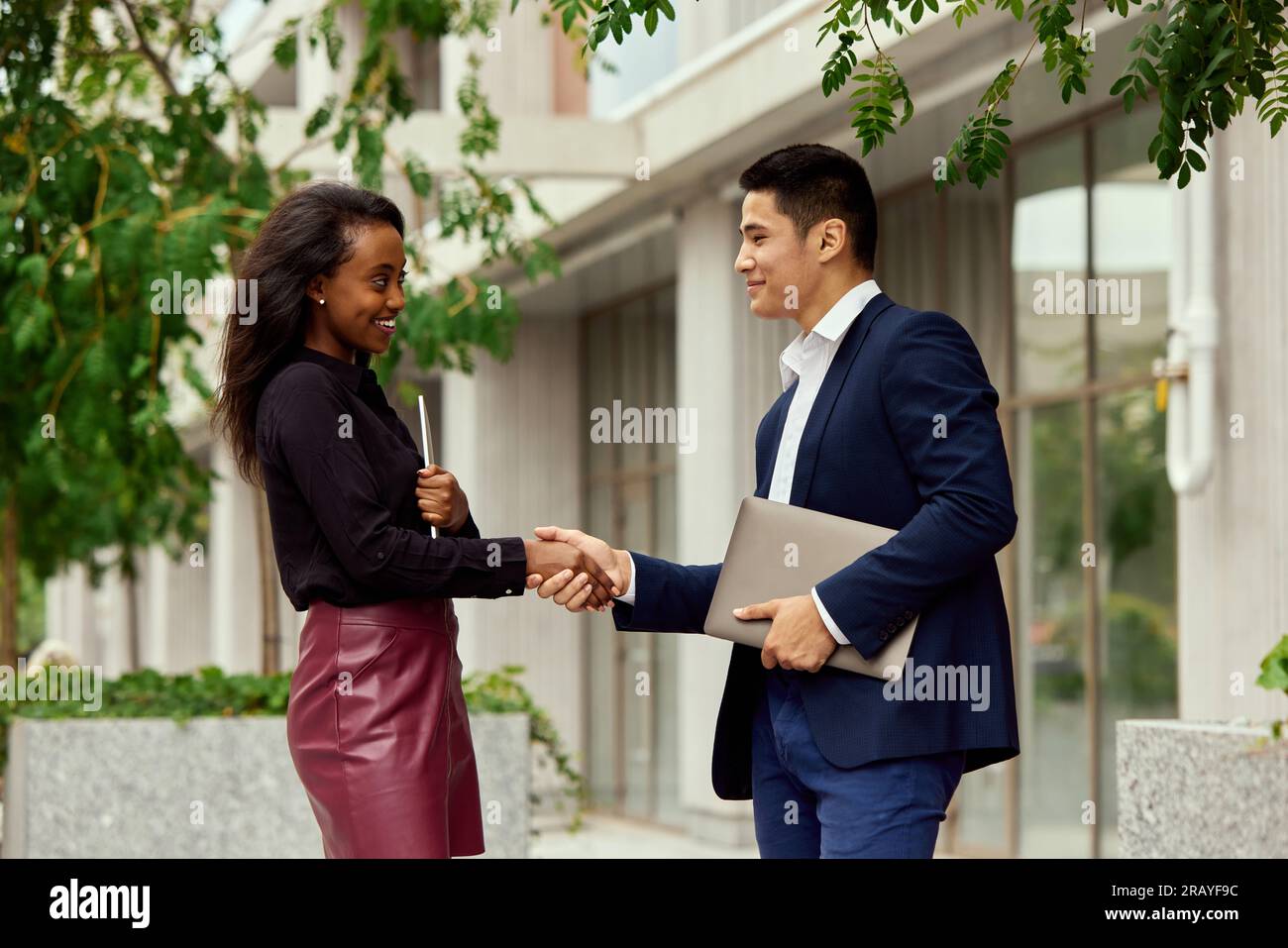 Cooperation and partnership. Man and woman, managers shaking hands in ...