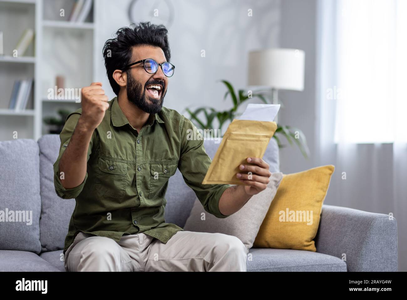 Joyful hispanic received letter mail notification man sitting at home ...
