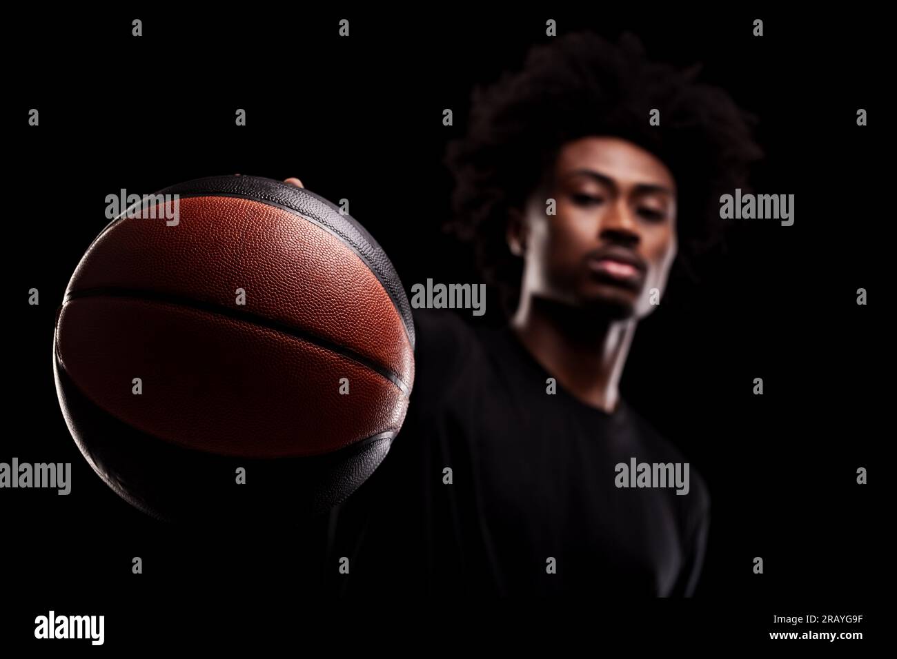Basketball player holding a ball at camera. Shallow focus. Young ...