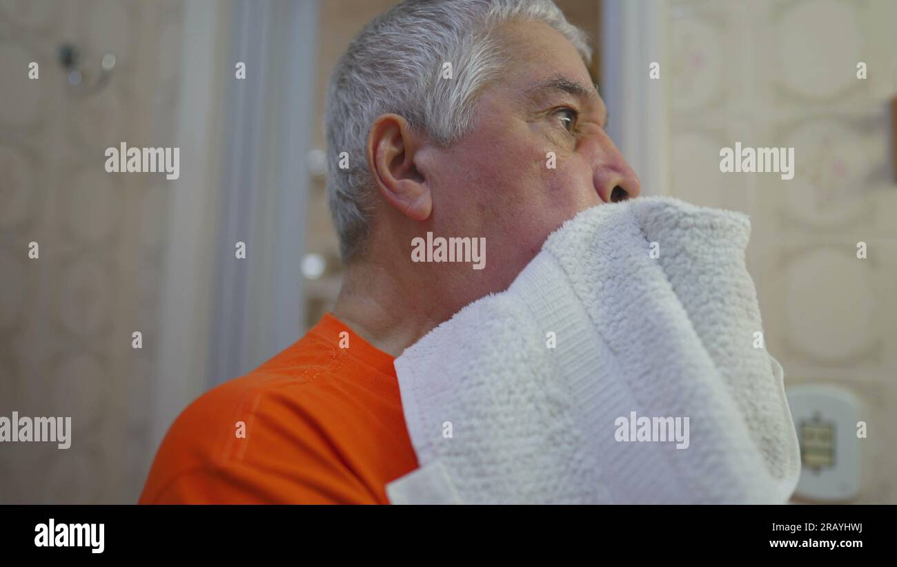 Senior man drying face with towel after washing morning routine Stock ...