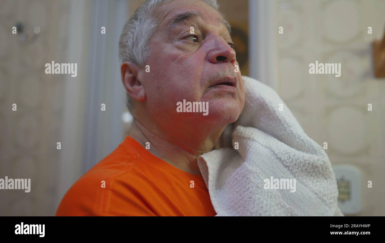 Senior man drying face with towel after washing morning routine Stock ...