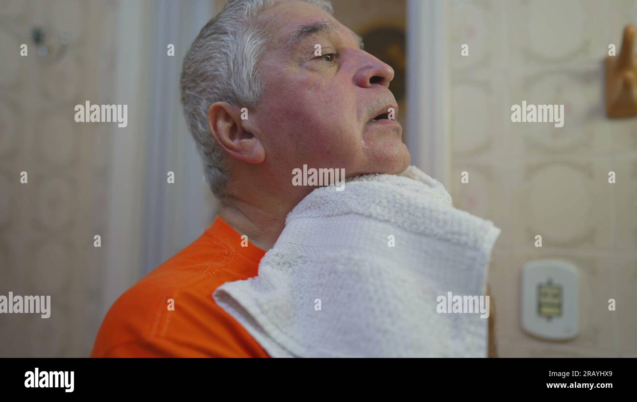 Senior man drying face with towel after washing morning routine Stock ...