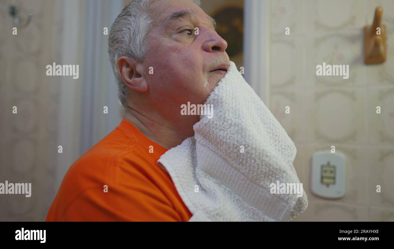 Senior man drying face with towel after washing morning routine Stock ...