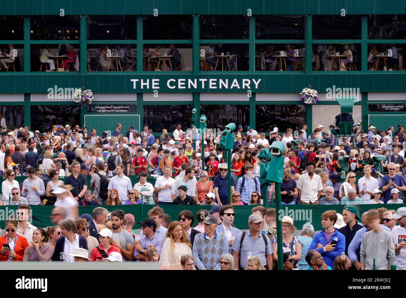 Spectators crowd the outside courts on day four of the Wimbledon tennis ...