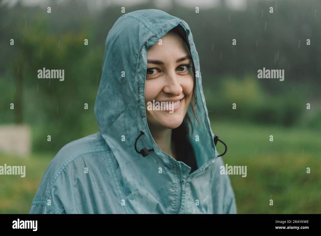 Portrait of a young girl in a blue raincoat enjoying the rain Stock ...