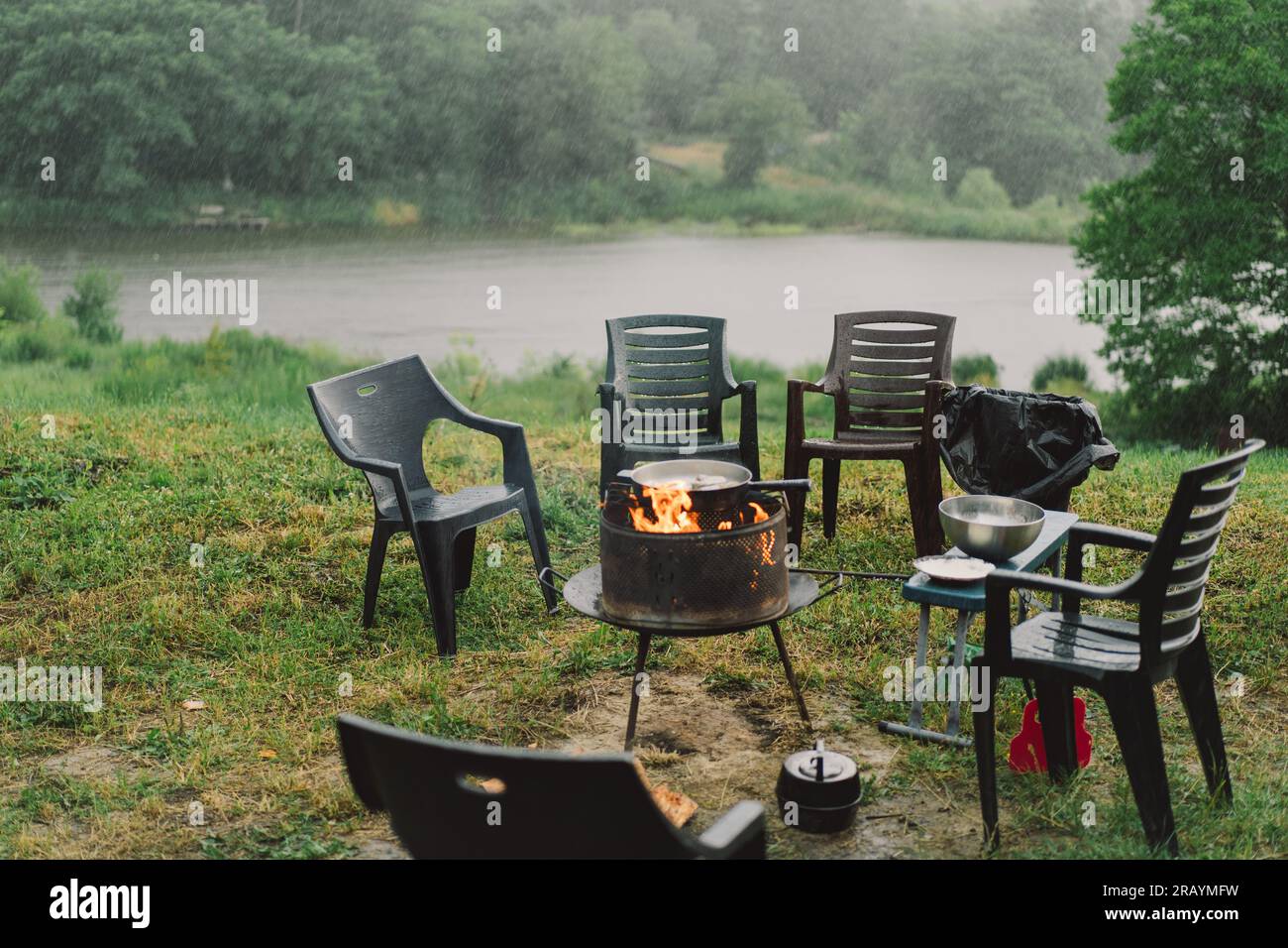 Man cooking fish on fire in nature, camping outdoors Stock Photo - Alamy