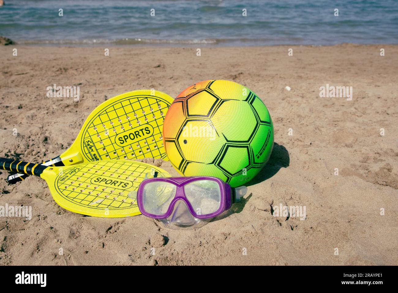 Beach tennis racket and ball, swimming mask ,and beach volleyball ball ...