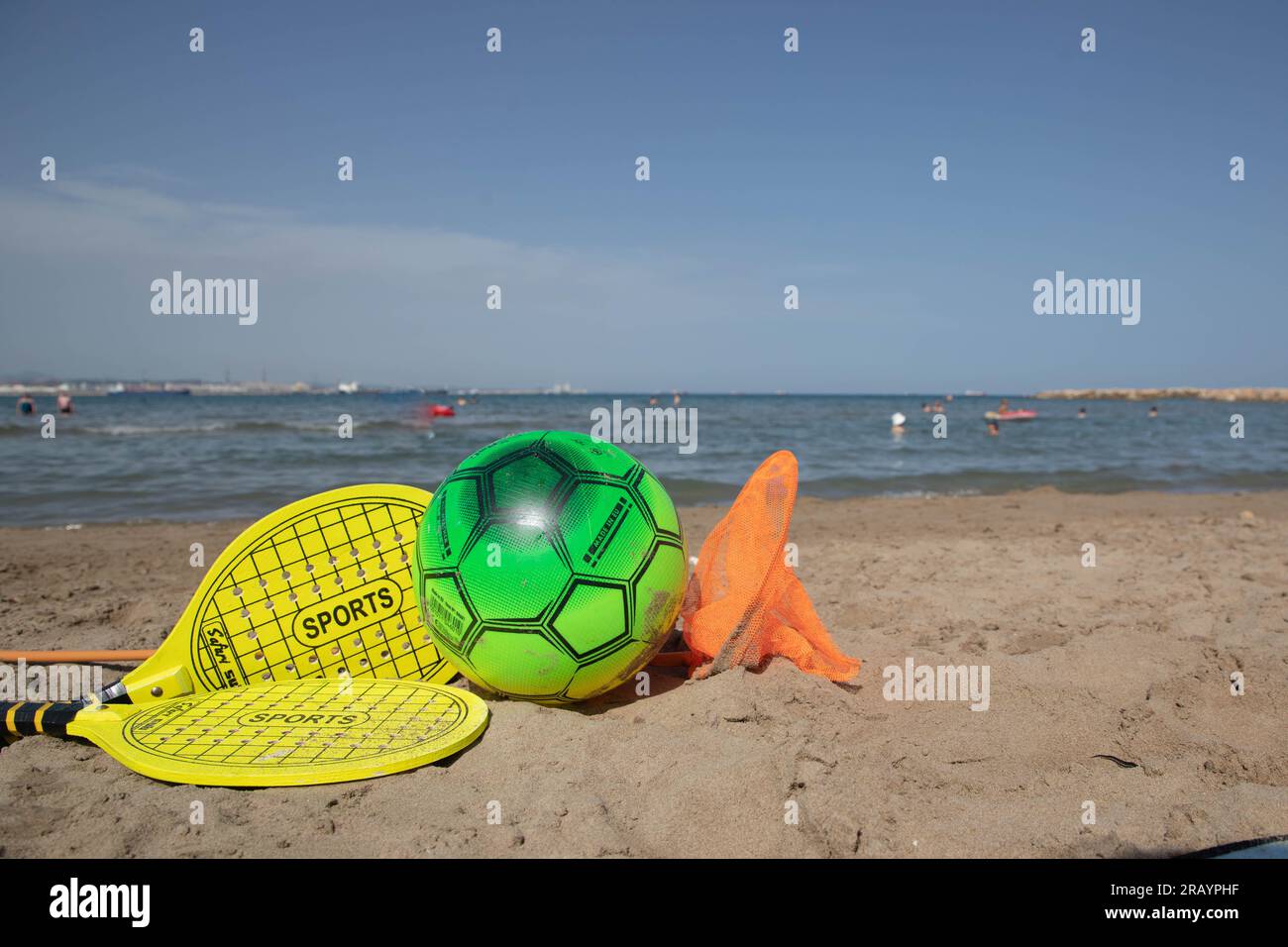 Beach tennis racket and ball, and beach volleyball ball on tne beach ...