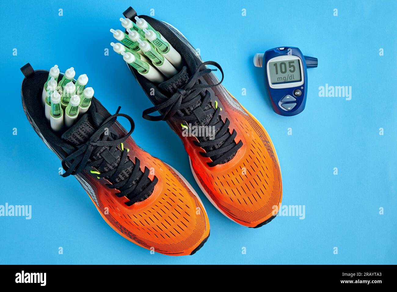 Orange running shoes with insulin syringe pens and a glucometer for ...