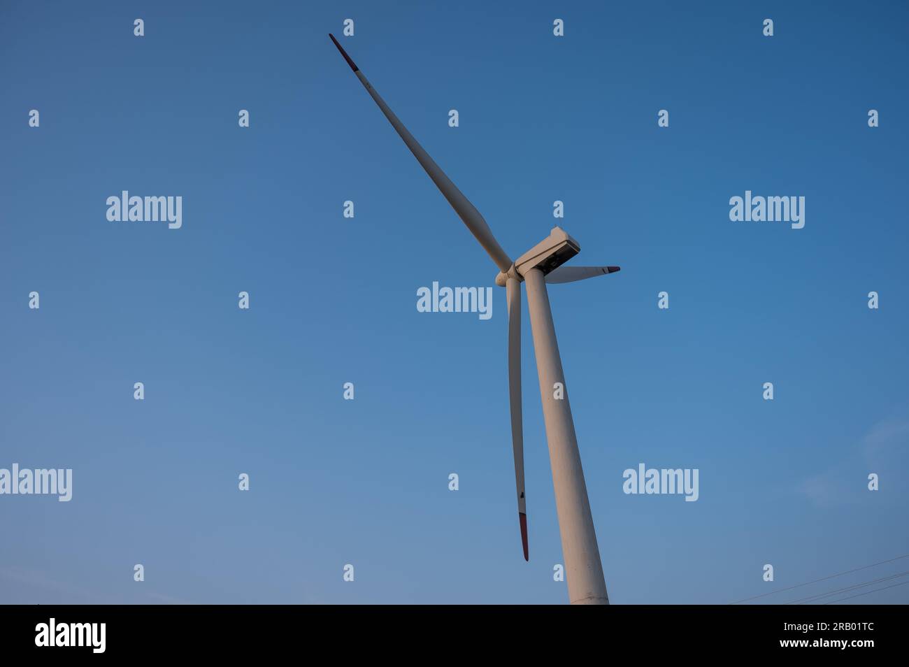 Bottom view of a windmill against a blue sky. Alternative energy source ...