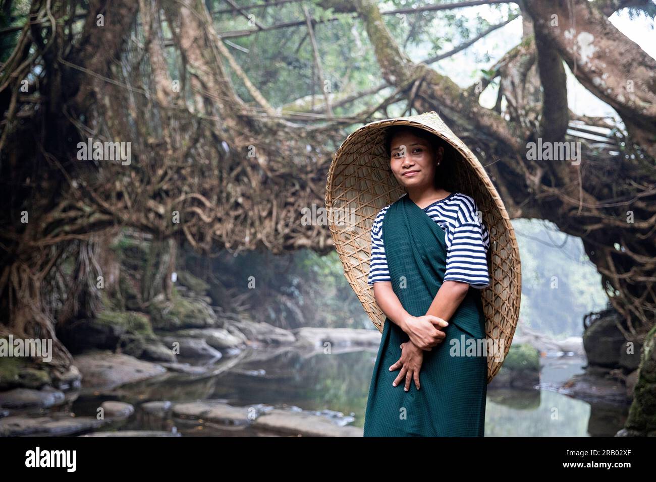 Young woman wearing traditional head rain cover standing by the river ...