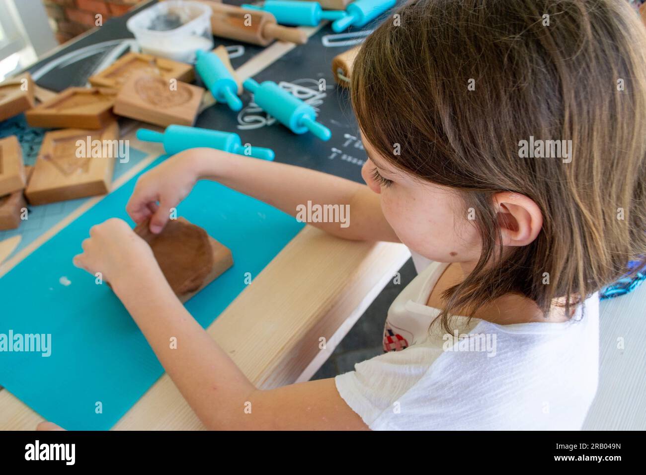 Rolling pin and floury gingerbread. Bakers hand spraying egg-white on ...