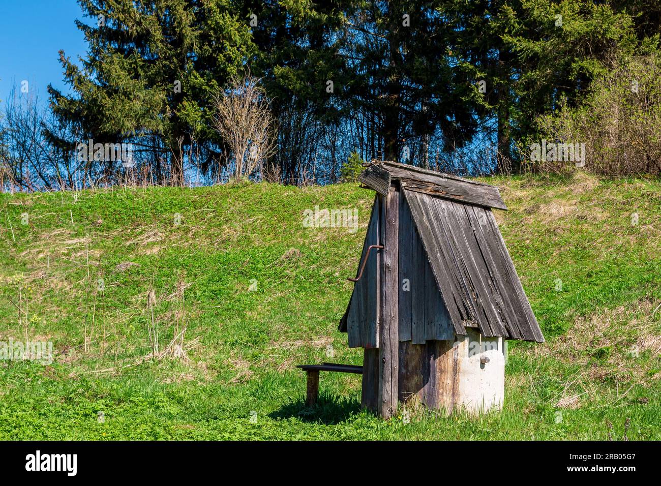 Old village well in the middle of a green lawn Stock Photo - Alamy
