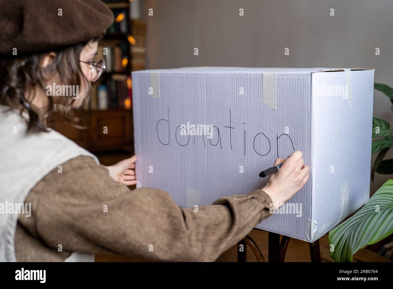 Volunteer girl eco activist signs donation box. Reuse clothes social ...