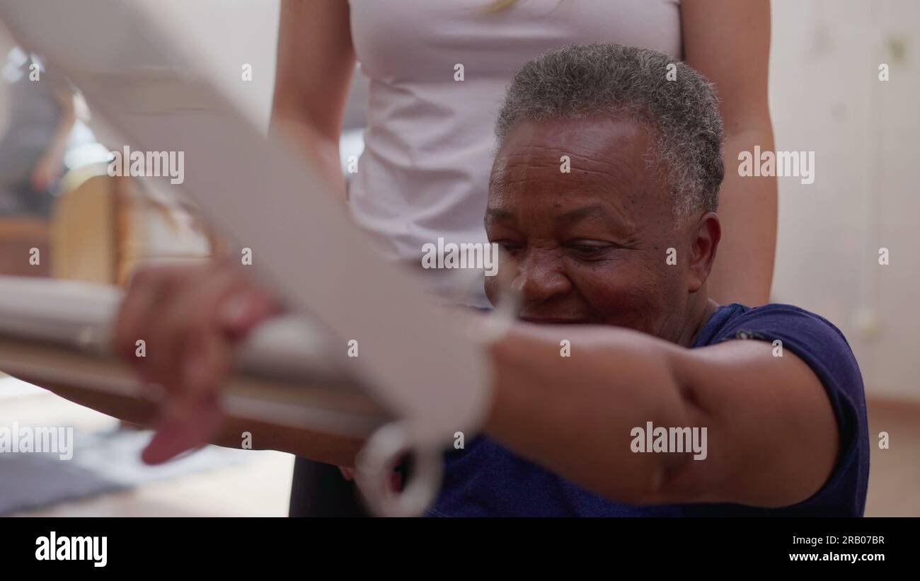 Female Sport Coach assisting a Black African American Senior woman to ...