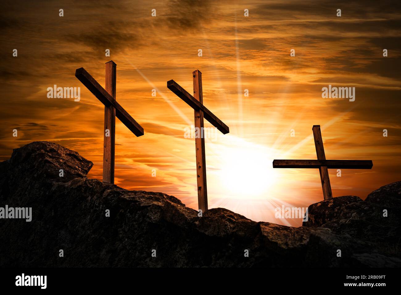 Silhouette of three wooden religious crosses above the hill against a dramatic sky and sunbeams ...