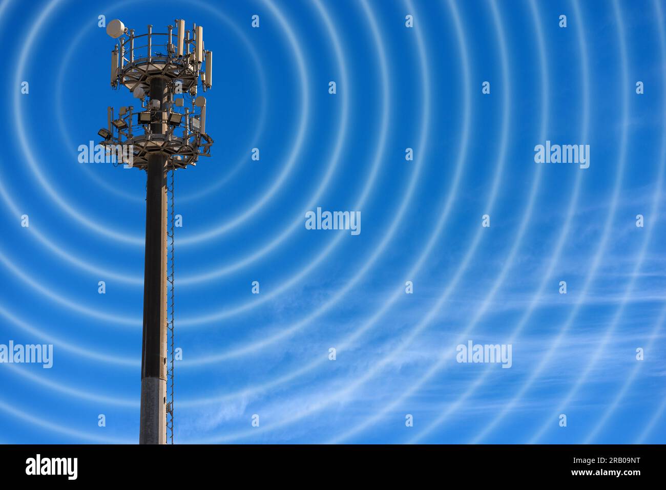Closeup of a telecommunications tower with antennas (aerial) and radio waves, against a clear ...