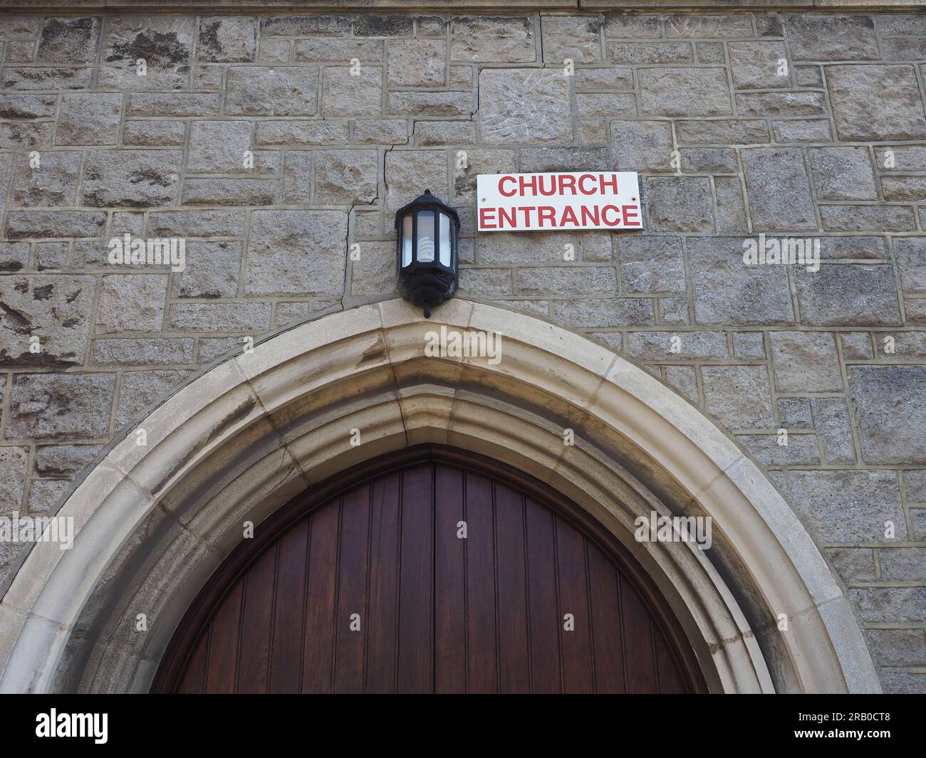 church entrance sign on a stone wall above a gothic arch Stock Photo ...
