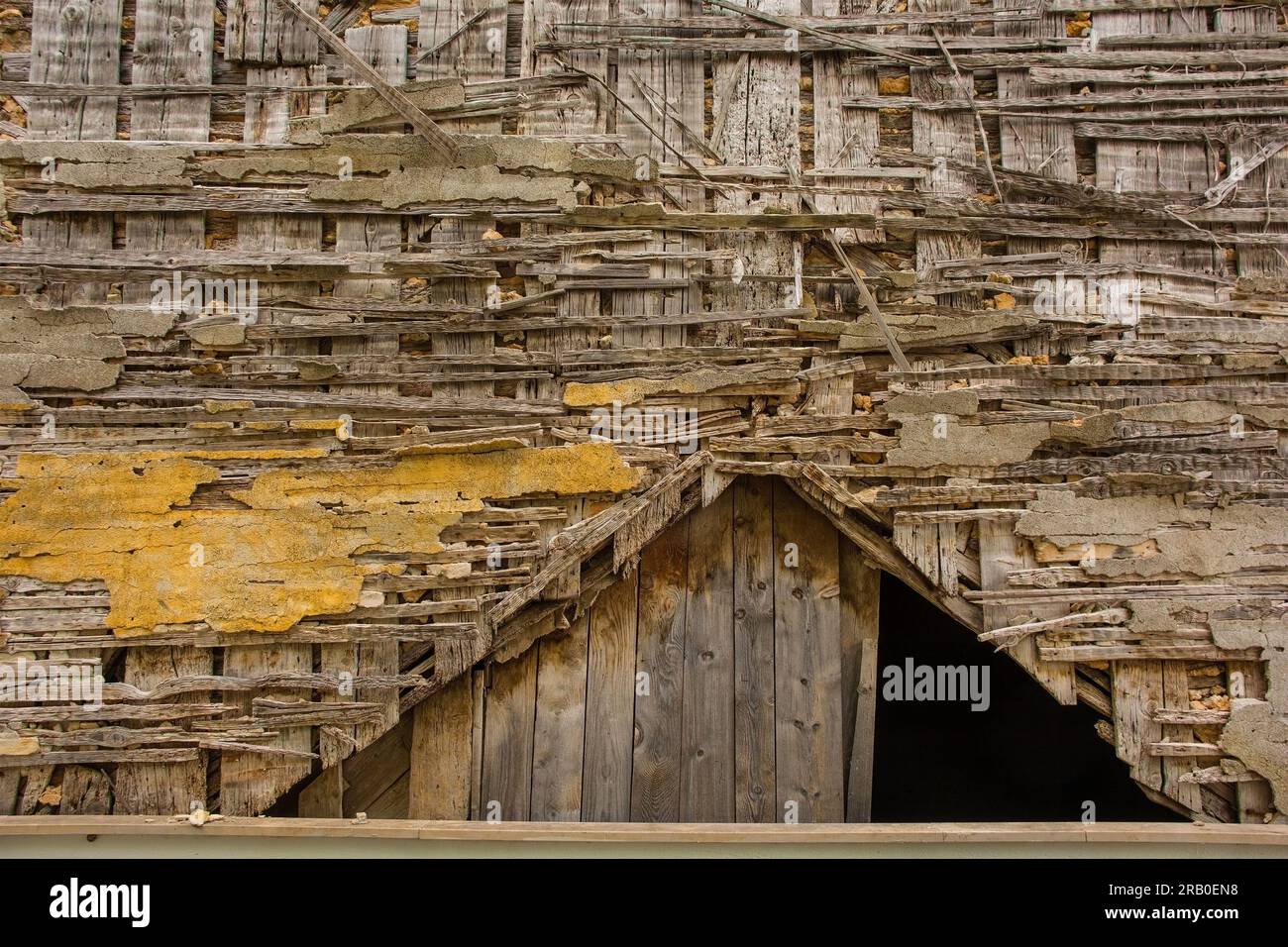 Detail from an old decaying wooden wall where a roof was once joined ...