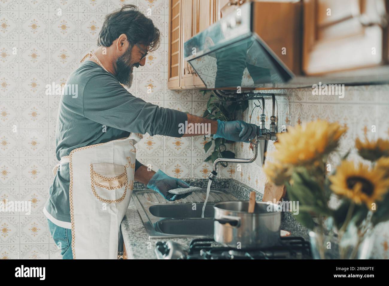 Husband one man washing dishes at home alone smiling and enjoying ...