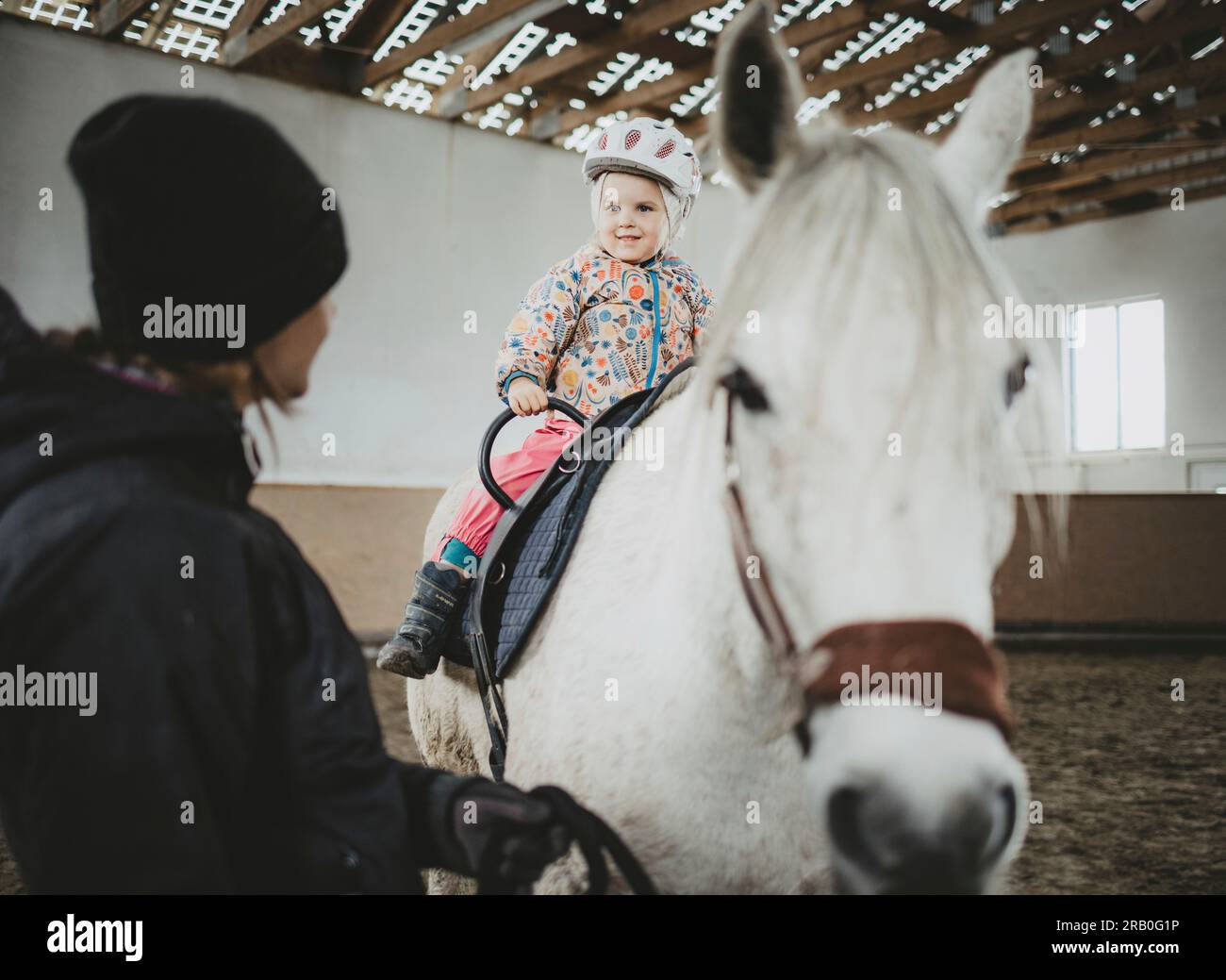 Mother and daughter with horse in riding hall hi-res stock photography ...