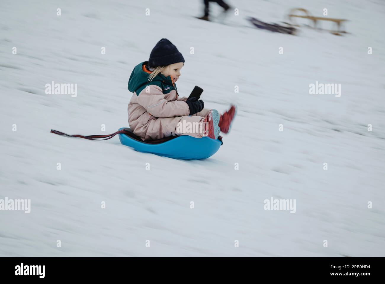 Little girl sledding Stock Photo - Alamy