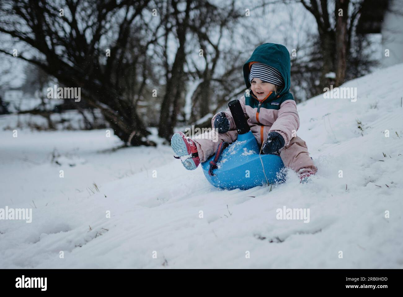Little girl sledding Stock Photo - Alamy