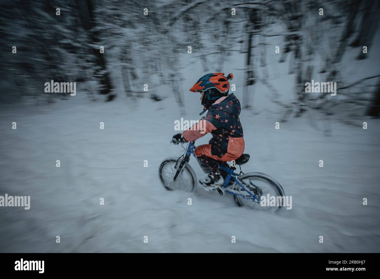Boy riding farm bike in snowy forest Stock Photo - Alamy