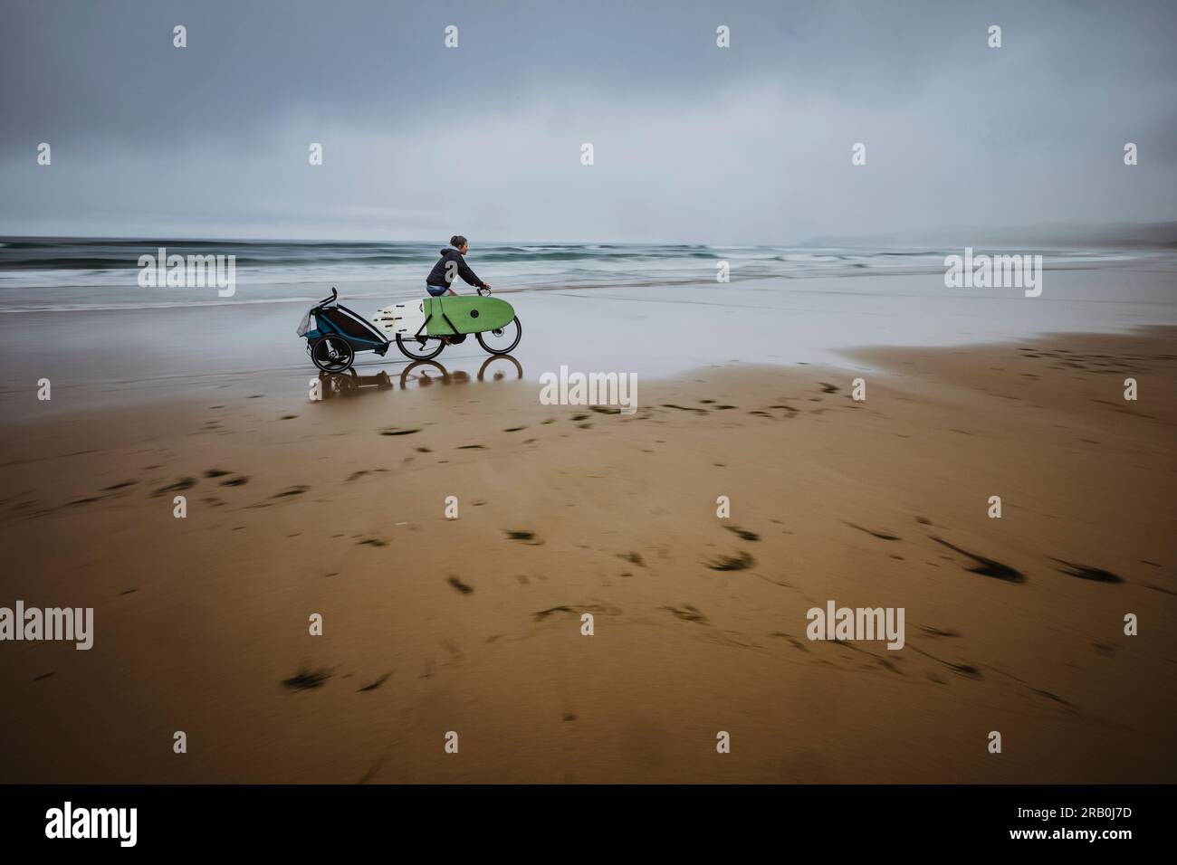 Surfer woman with bike and trailer on beach Stock Photo - Alamy