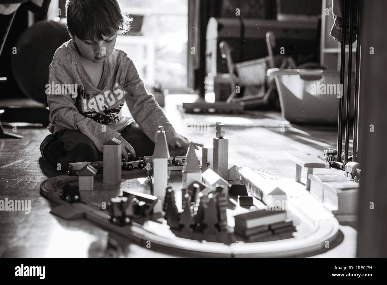 Boy playing with wooden train set at home Stock Photo - Alamy