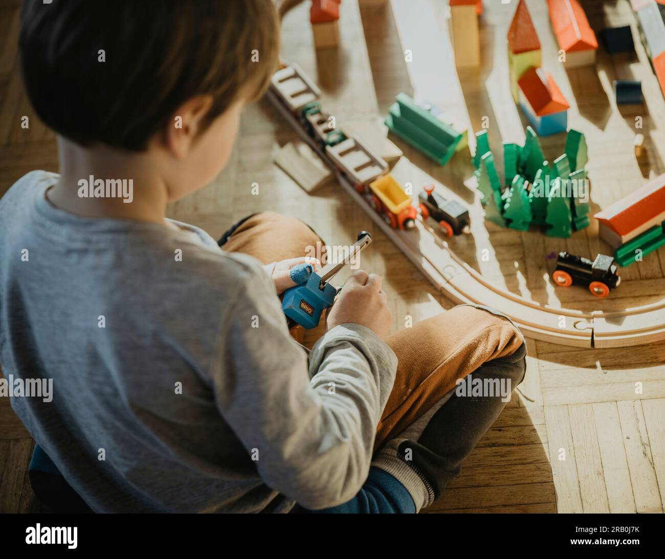 Boy playing with wooden train set at home Stock Photo - Alamy