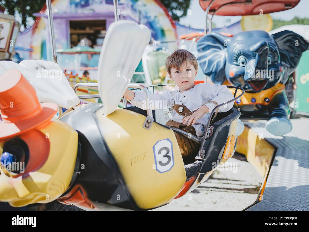 Boy rides carousel at a fairground Stock Photo - Alamy