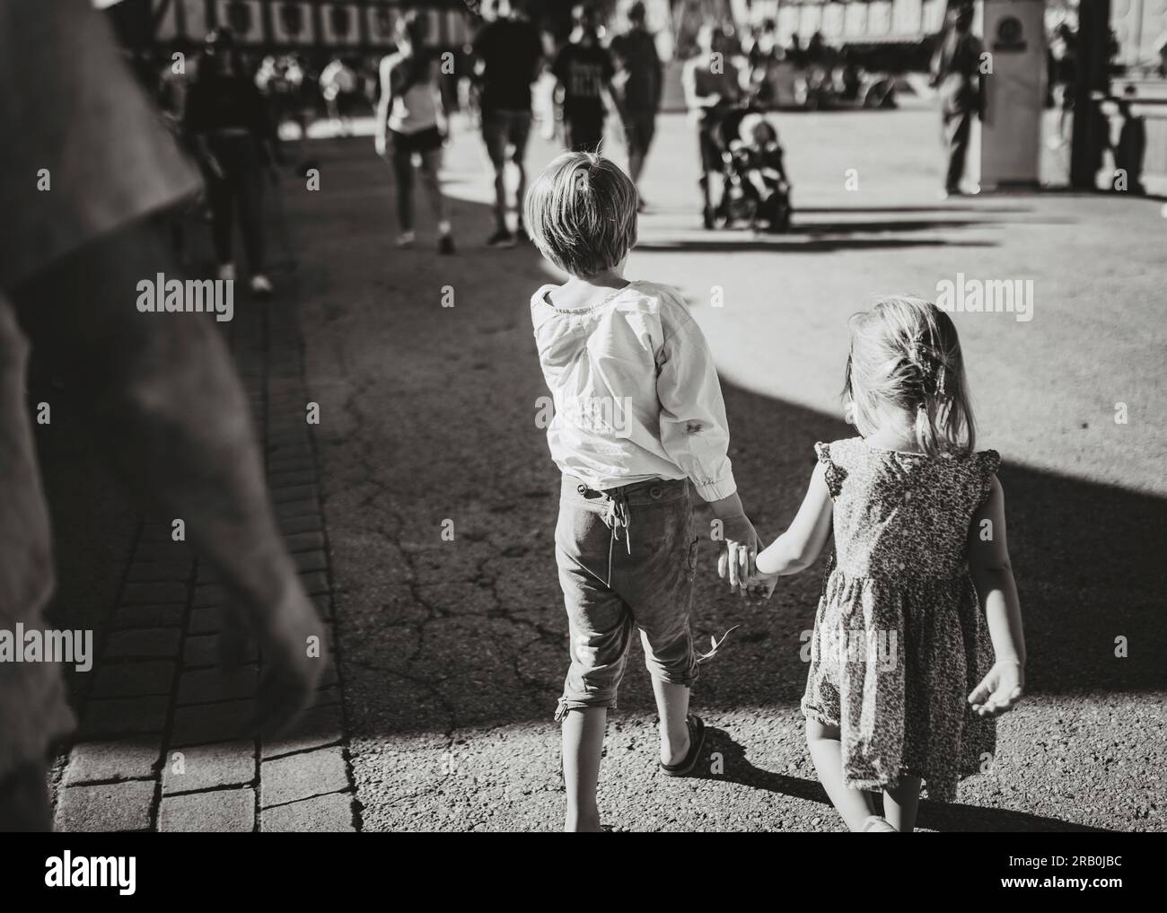 Brother and sister walk hand in hand through a fairground Stock Photo ...