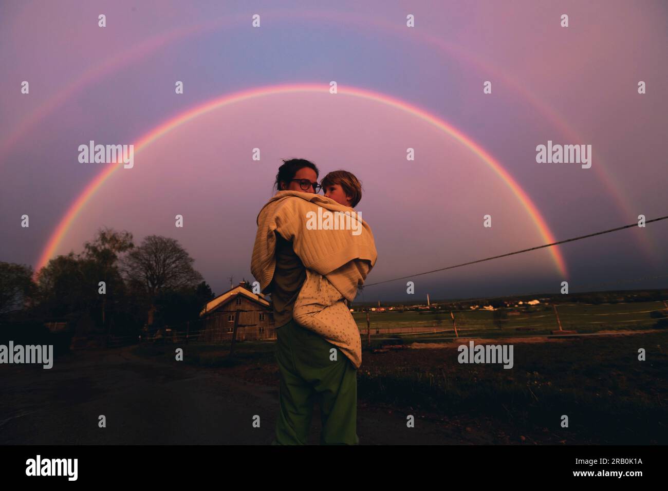 Mother and son look at double rainbow Stock Photo - Alamy