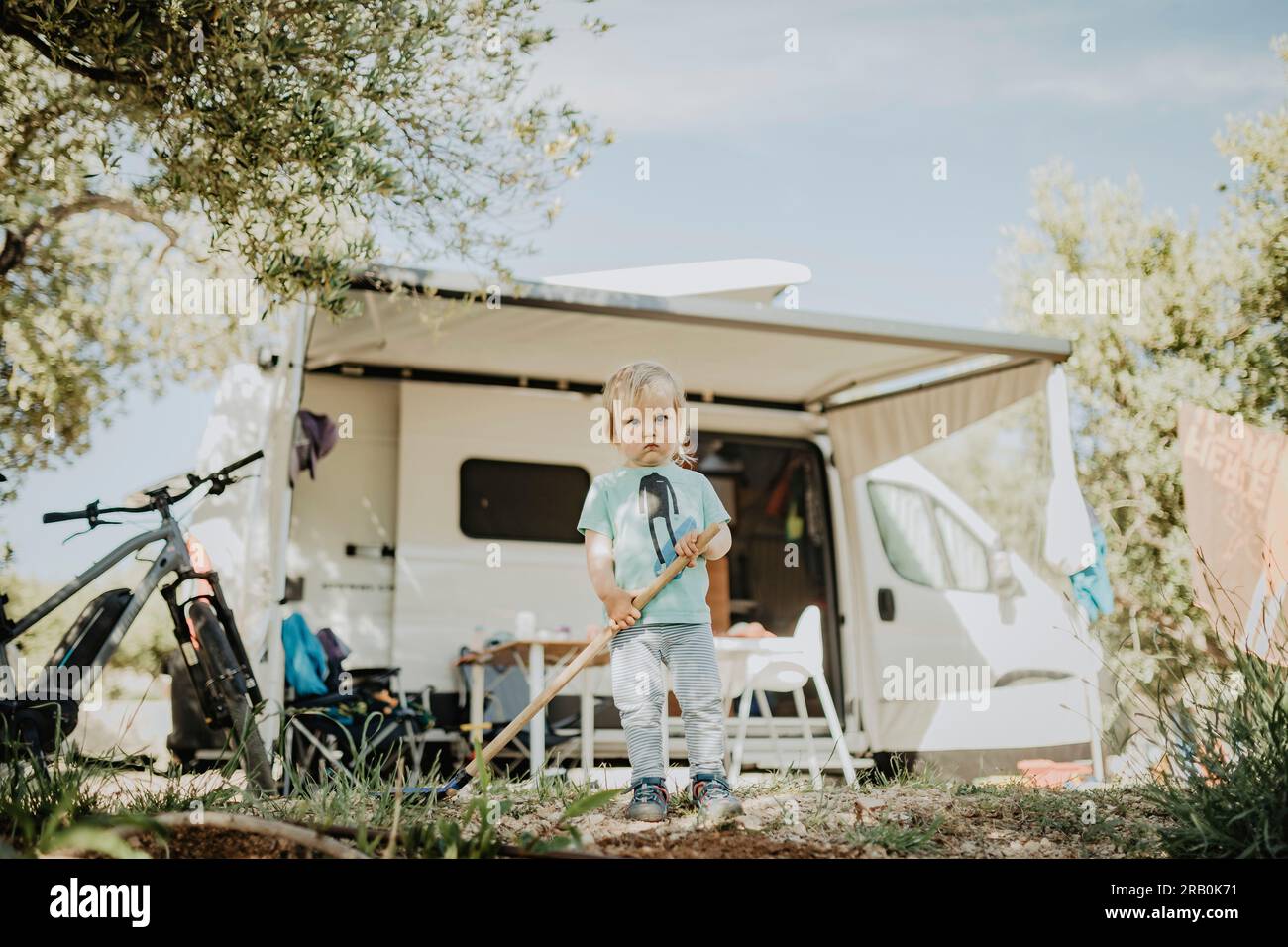 Little girl playing in front of camper van on a campsite Stock Photo ...