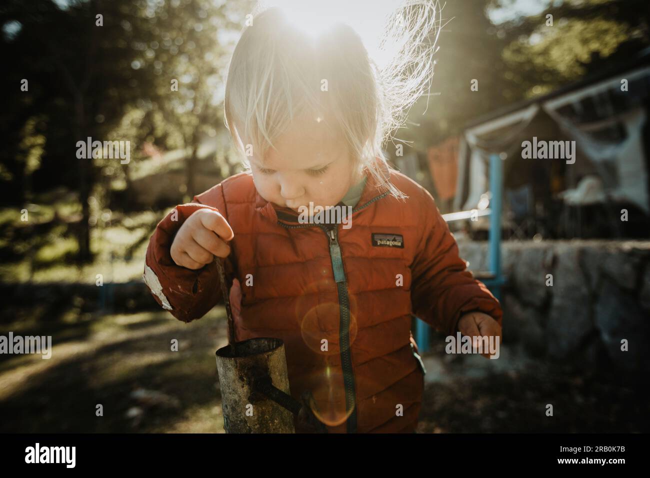 Girl playing with stick at campsite Stock Photo - Alamy
