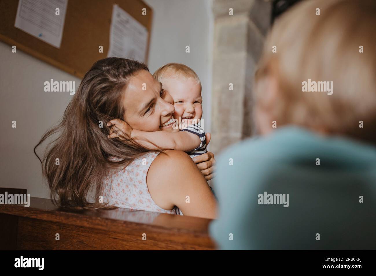 Mother sitting on bench with her children Stock Photo - Alamy