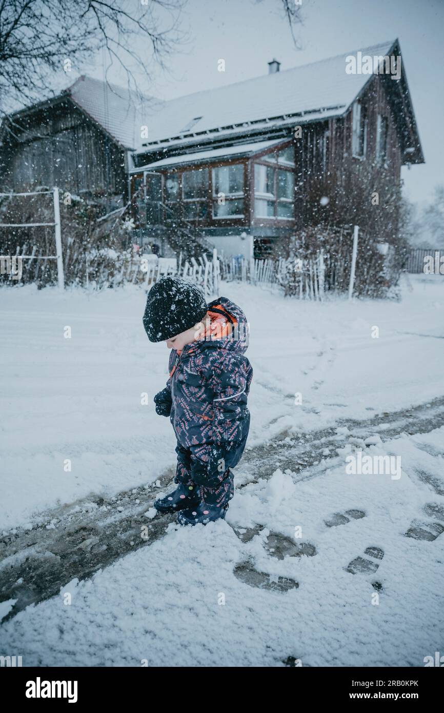 Little girl makes footprints in snow Stock Photo - Alamy