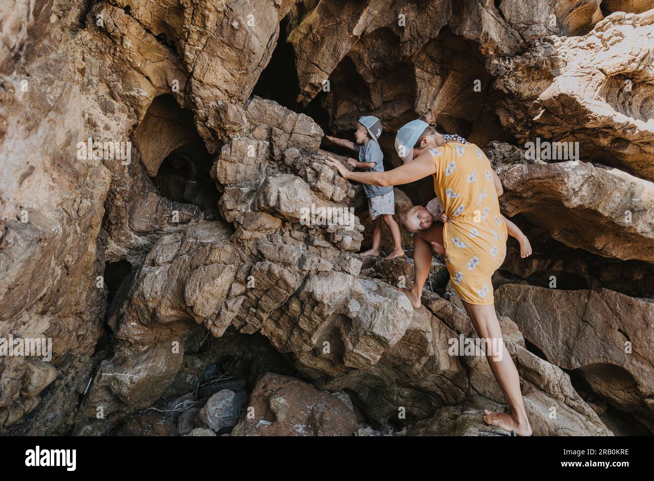 Mother climbing with children on rock Stock Photo - Alamy