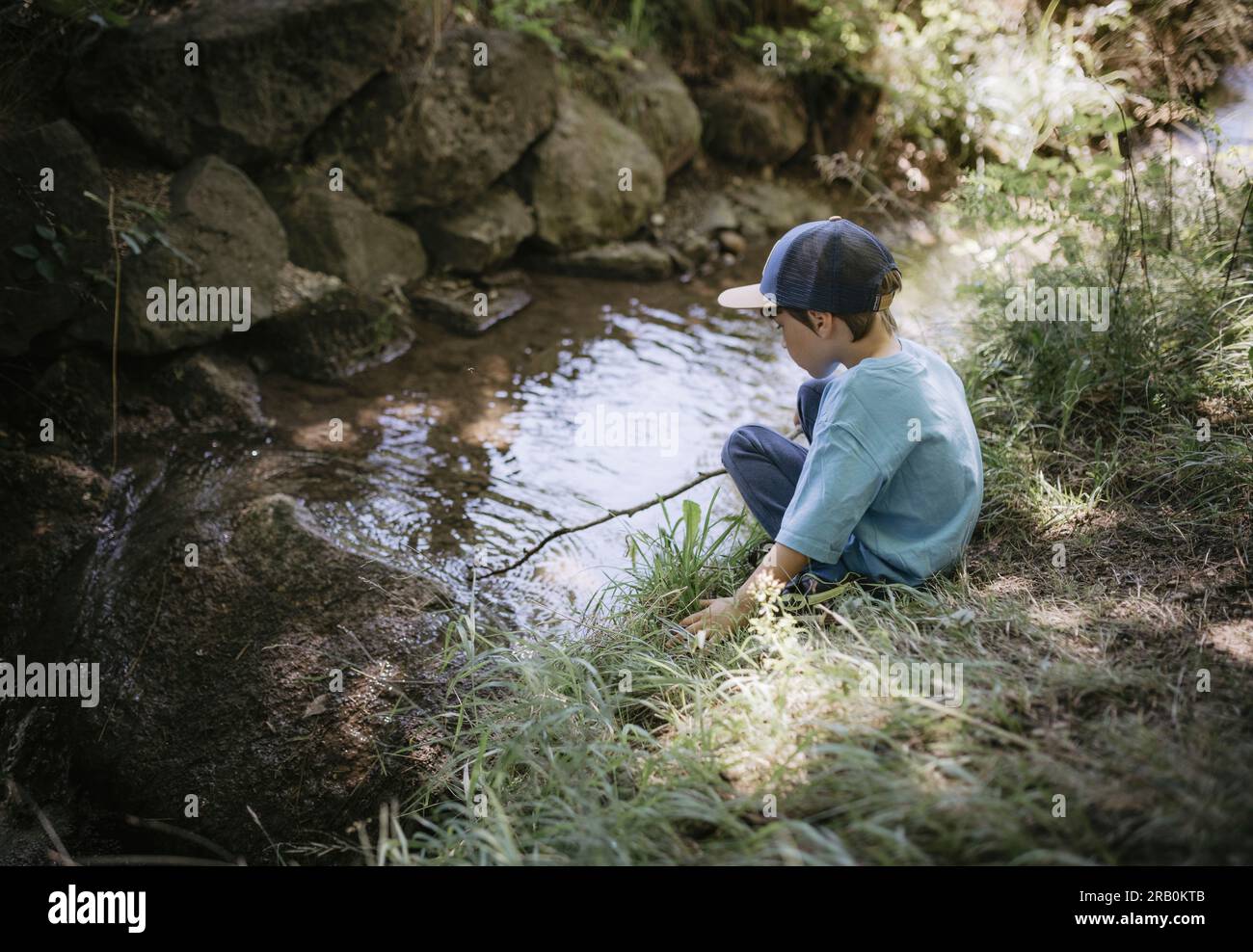 Boy playing by a stream Stock Photo - Alamy