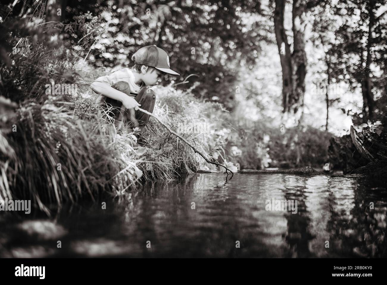 Boy playing by a stream Stock Photo - Alamy