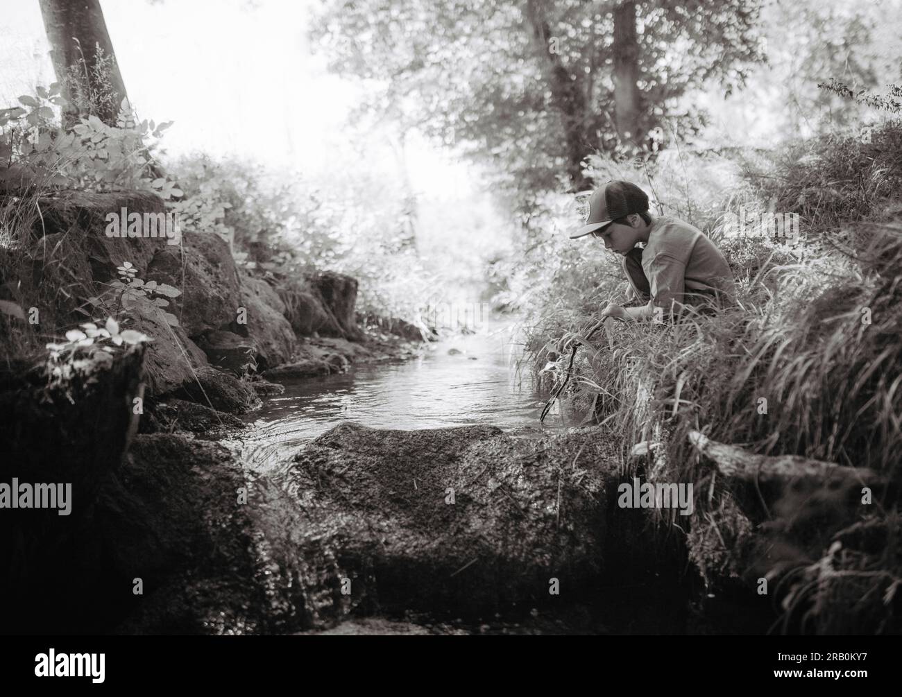 Boy playing by a stream Stock Photo - Alamy