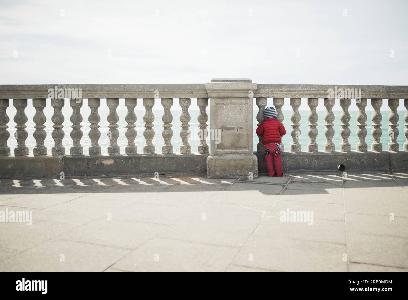 Little boy looking through parapet of waterfront, Cadiz, Spain Stock Photo - Alamy