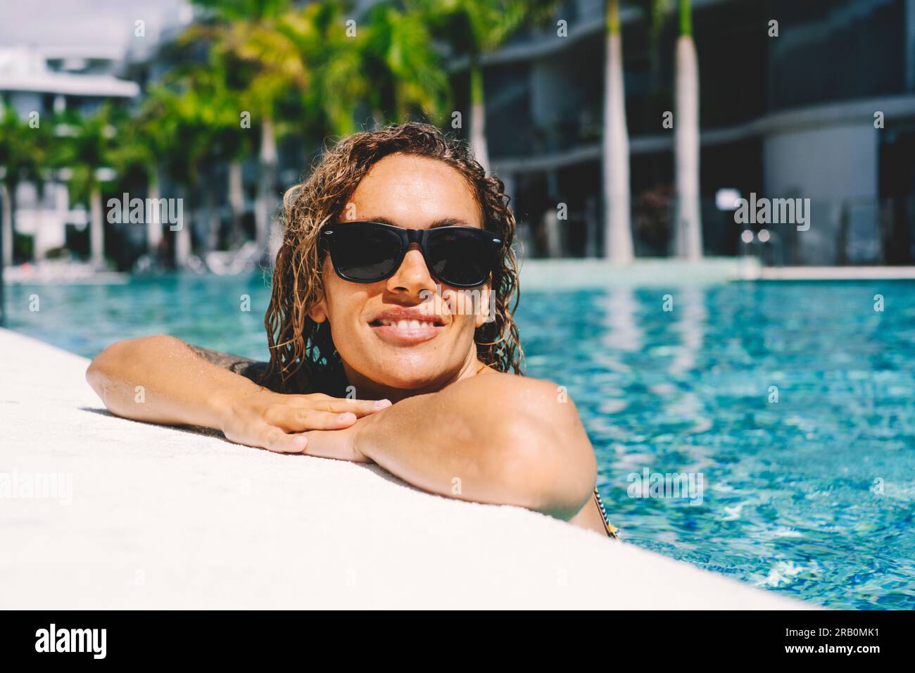 Happy woman enjoy sun and pool in hotel resort scenic holiday place ...