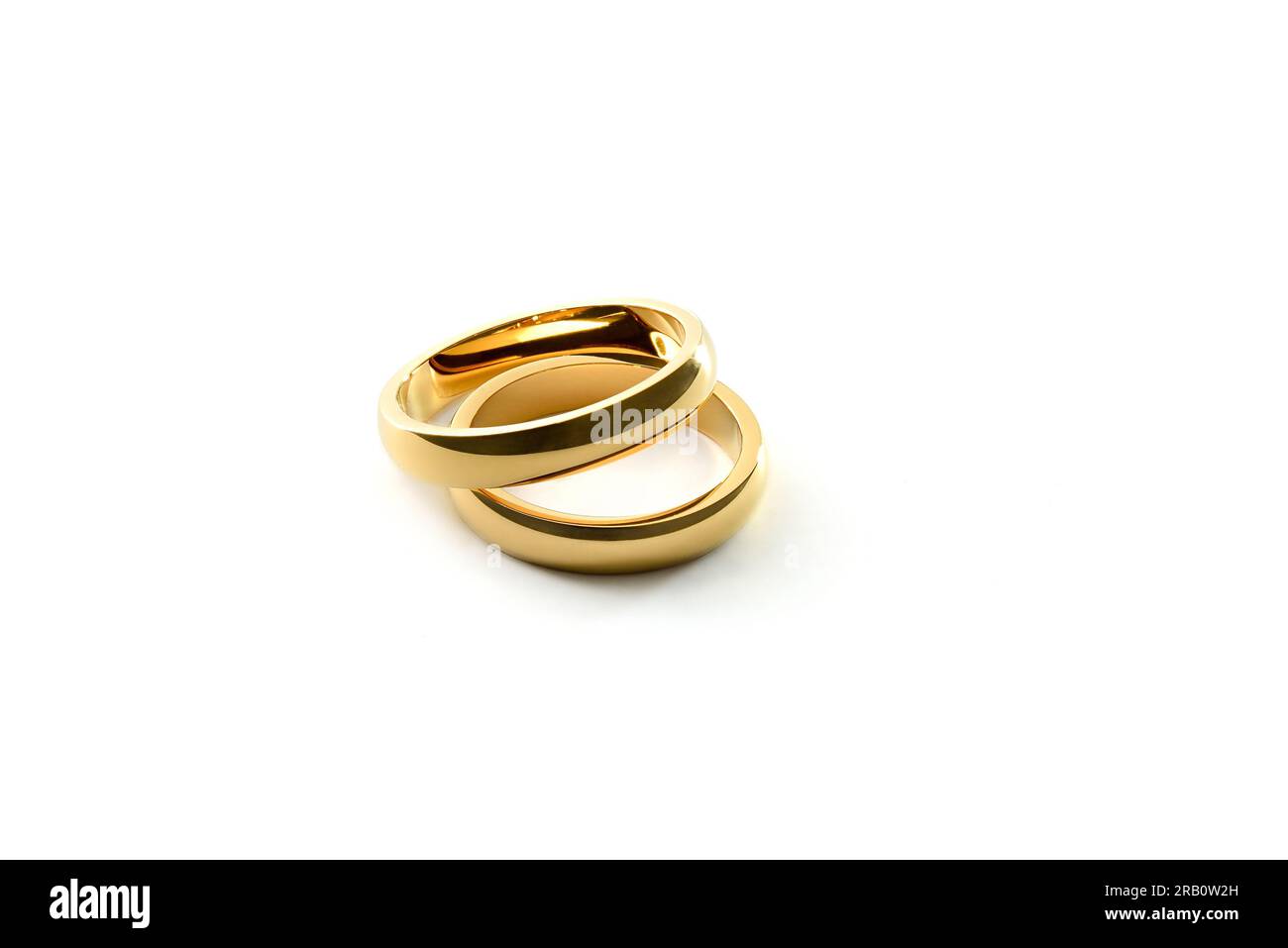 Detail of overlapping gold engagement rings on white isolated ...