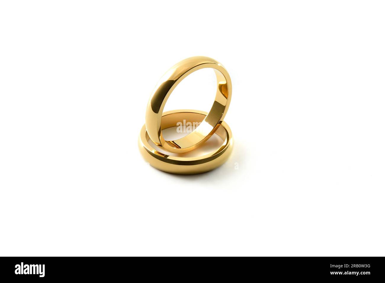 Detail of engagement gold ring standing inside of each other on white ...