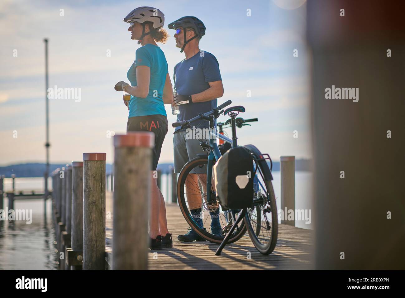 Couple, man and woman touring with bicycles, trekking bike, resting on jetty Stock Photo - Alamy