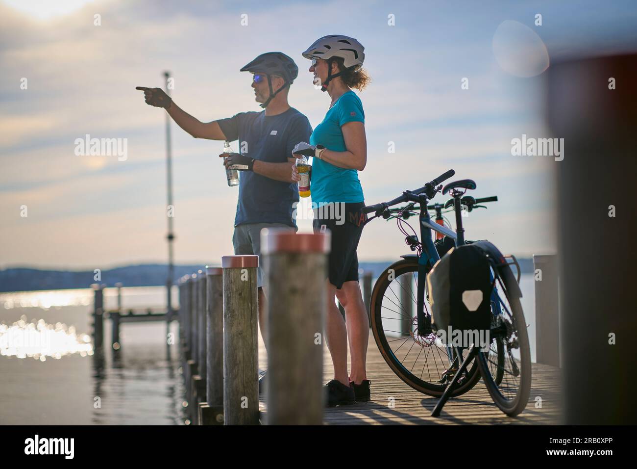 Couple, man and woman touring with bicycles, trekking bike, resting on jetty Stock Photo - Alamy